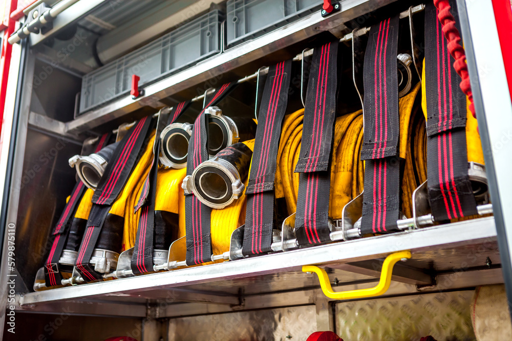 Compartment of rolled up fire hoses on a fire engine. Rescue fire truck ...