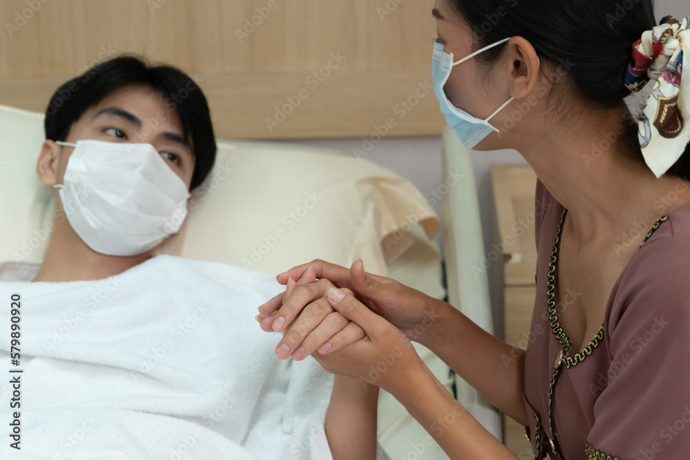 Young Patient With Attentive Visitor And Family Holding Hands In young-patient-with-attentive-visitor-and-family-holding-hands-in