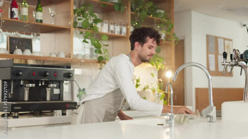 Man in coffee shop, barista cleaning countertop and working, busy and ...