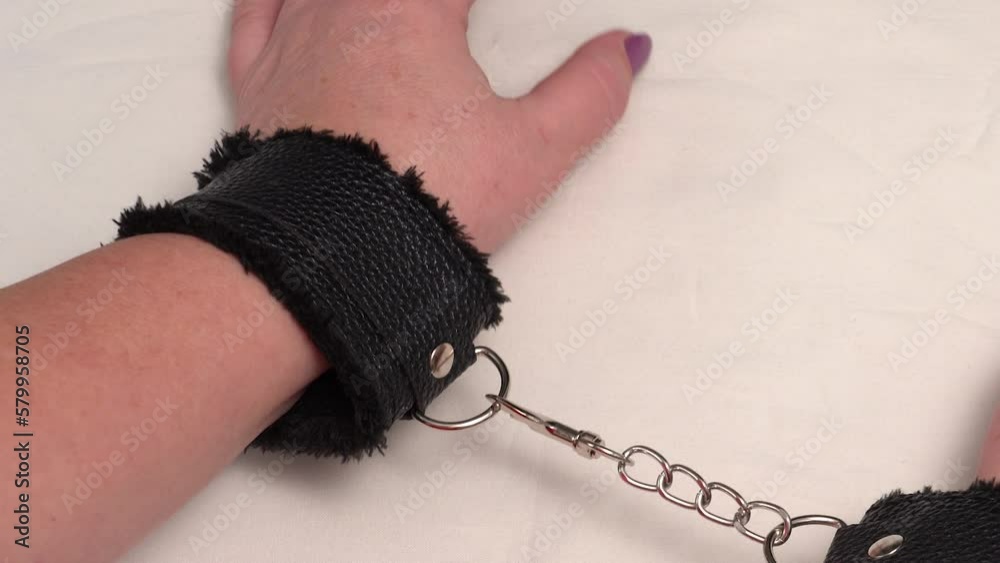 The lady is wearing black handcuffs with a soft leather lining, and ...