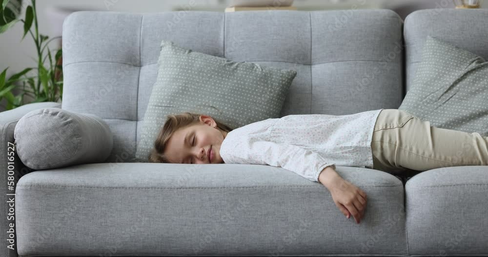 Sweet little child hitting soft home couch, resting on comfortable sofa ...
