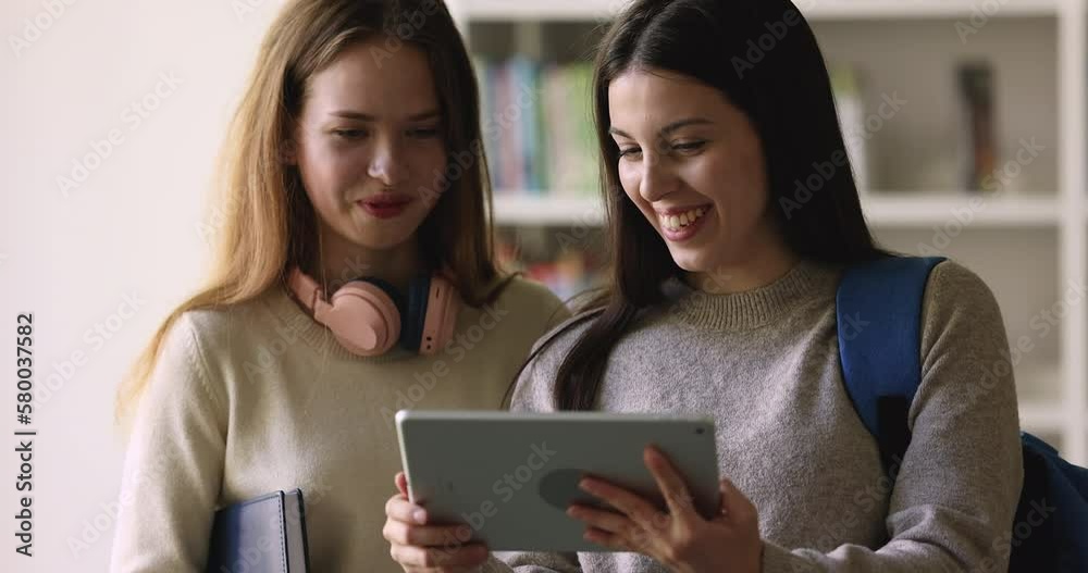 Video Stock Two happy classmates girls talking in library, standing ...