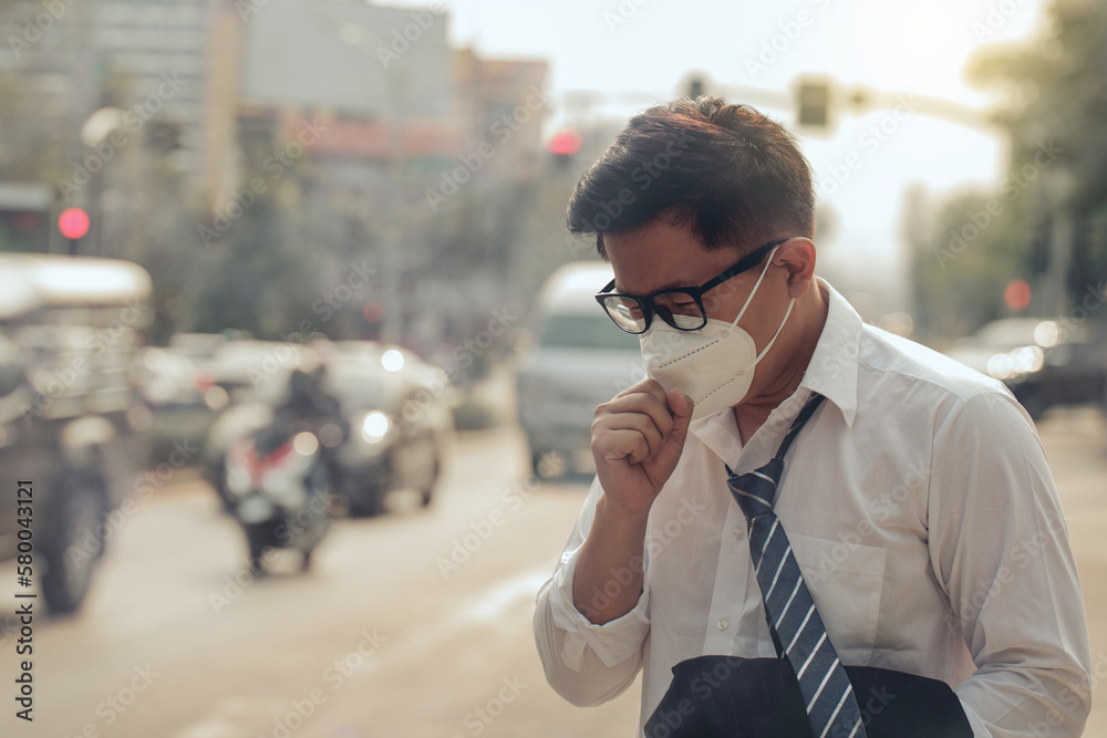 Foto de Business man wearing a mask and coughing on the street ...