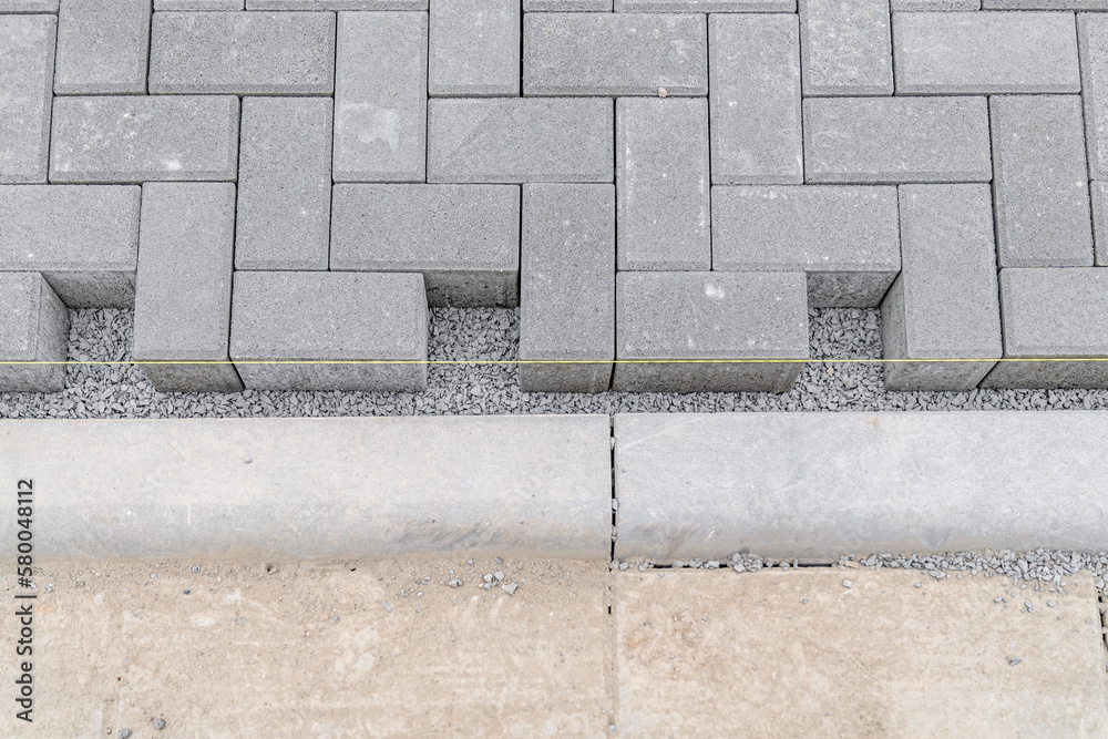 building a sidewalk, laying interlocking pavers Stock Photo | Adobe Stock
