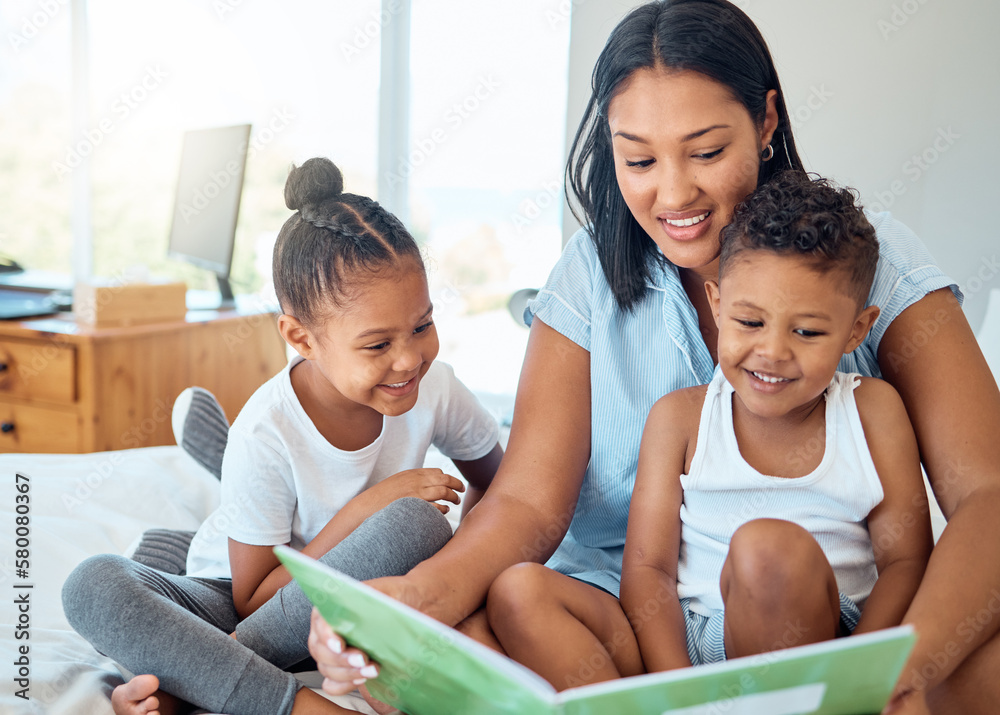Mother reading a book to her children in a bedroom to relax, bond and ...
