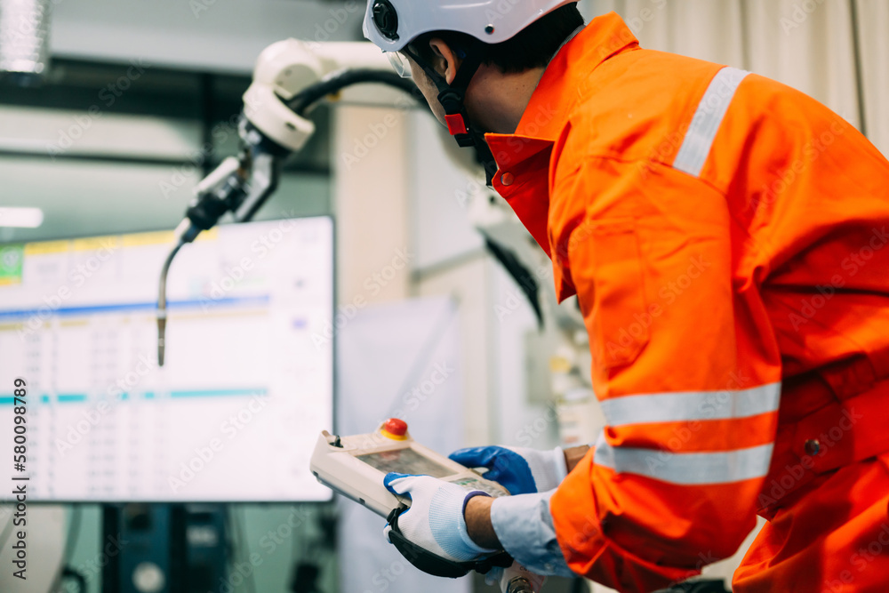 Professional engineer checking and repairing parts of robotic arm ...