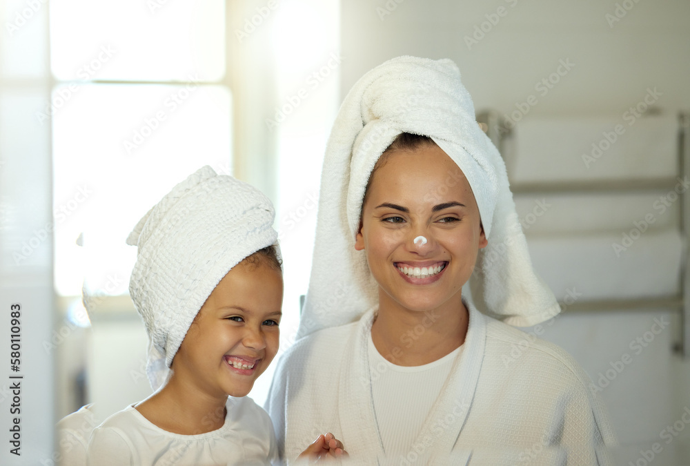 Playful mother and daughter doing a hygiene, skincare routine together ...
