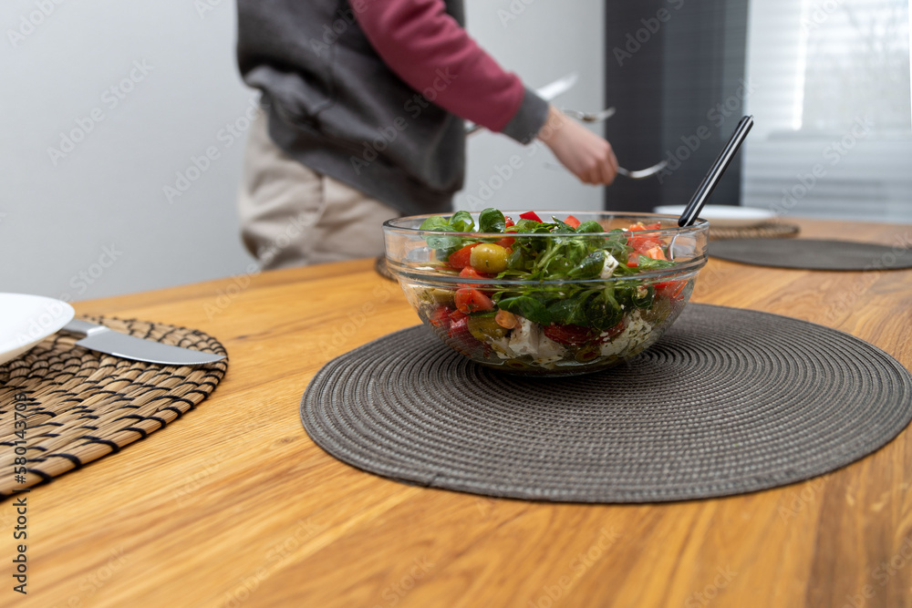 Woman with daughter setting the table for lunch time in her domestic ...