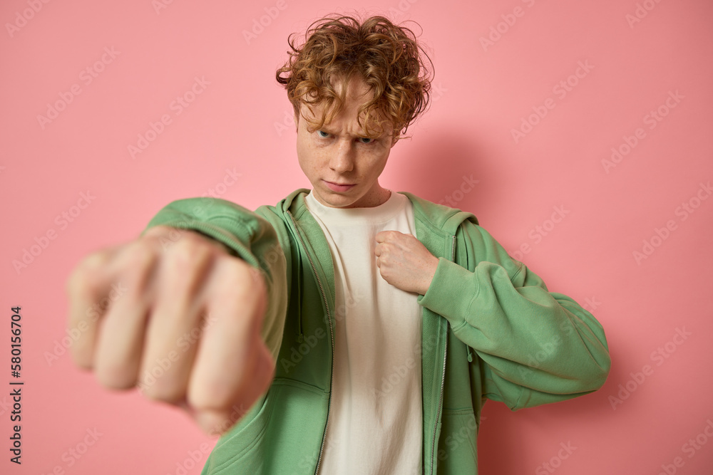 Horizontal shot of serious angry man with curly red hair, clenched ...
