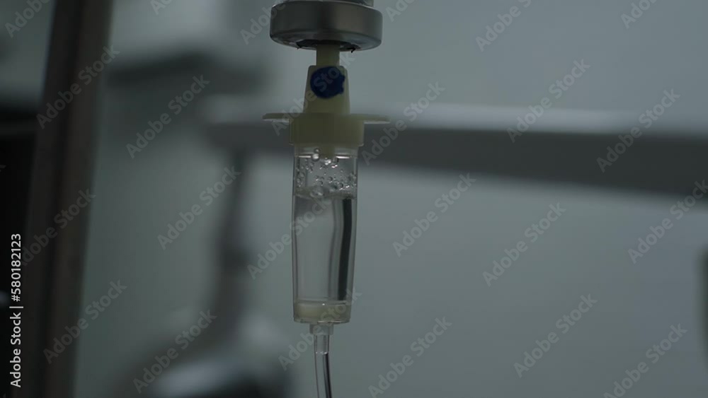 Close-up, slow motion. Dropper with slowly falling drops of a clear ...