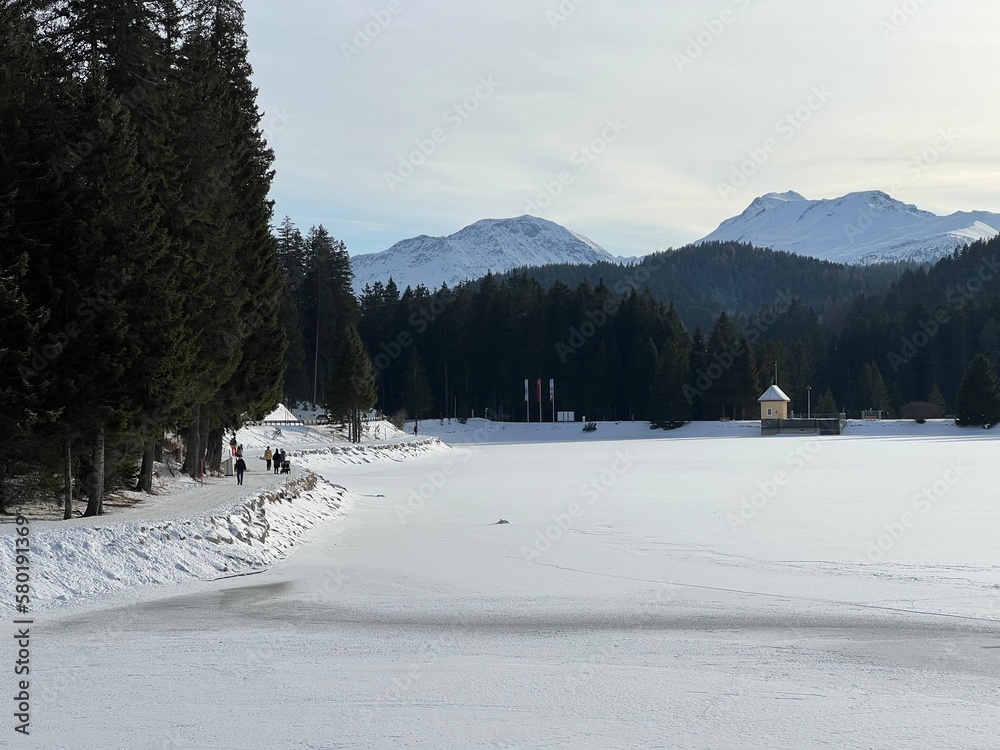 A typical winter idyll on the frozen and snow-covered alpine lake ...