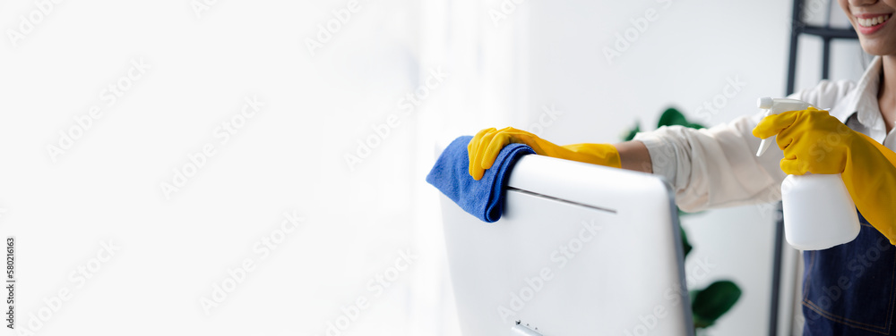 Person cleaning room, cleaning worker is using cloth to wipe computer ...