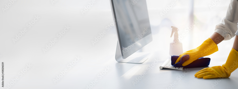 Person cleaning room, cleaning worker is using cloth to wipe computer ...