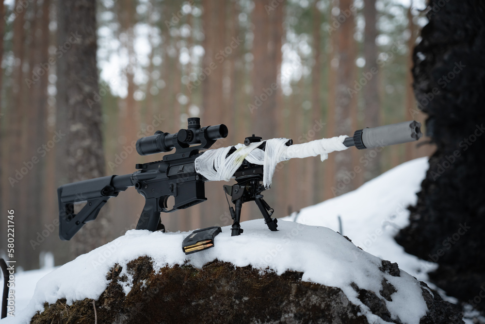 Sniper rifle ar 15 with optical sight and winter camouflage in a snowy ...