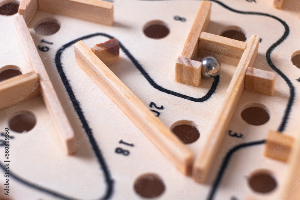 Wooden labyrinth toy marble maze game. Ball bearing navigating a ...