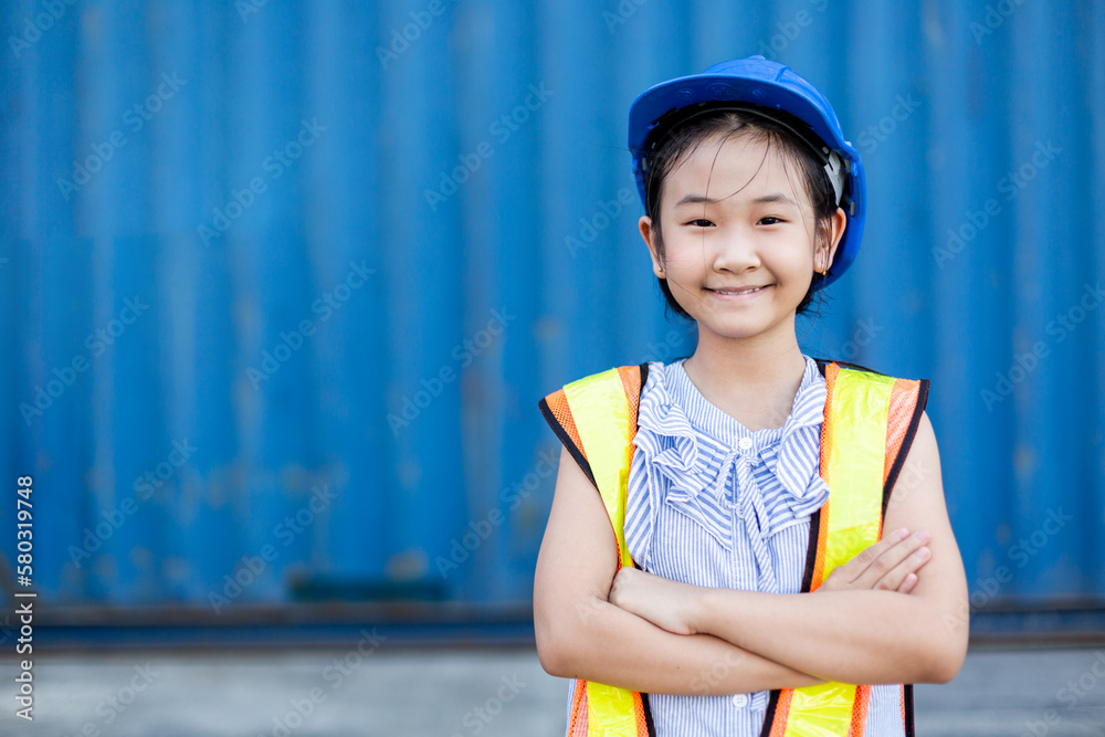 Happy smiling Asian little girl dress up engineer suit wearing hard hat ...