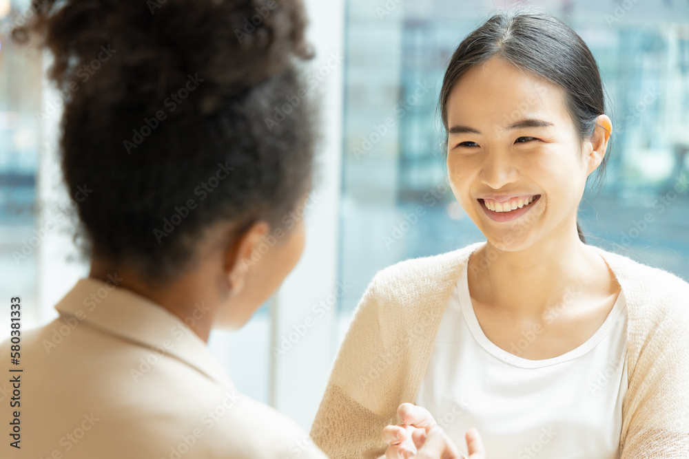 Photo & Art Print Asian woman talking fluently with her African friend ...