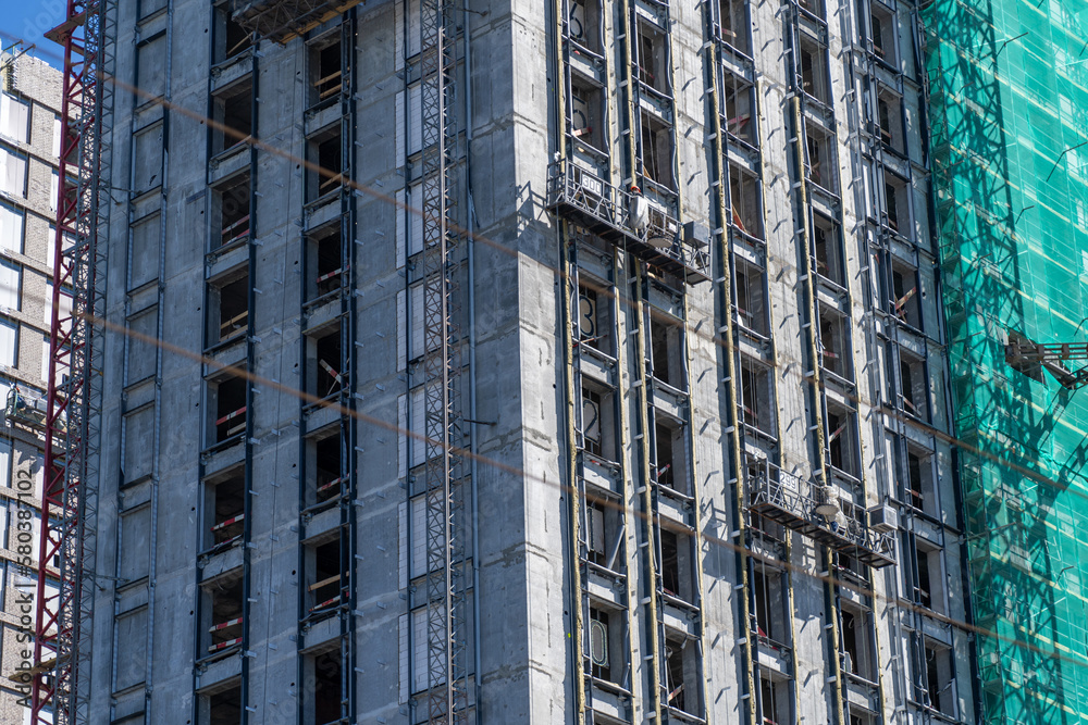 Monolithic concrete building under construction, facade with front view ...