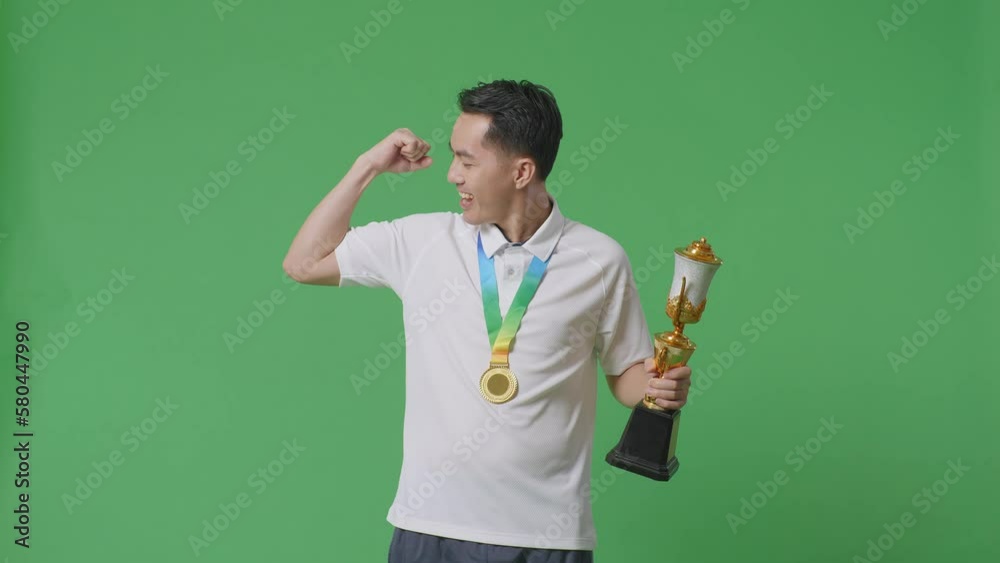 Asian Man With A Gold Medal And Trophy Flexing His Bicep And Smiling To ...