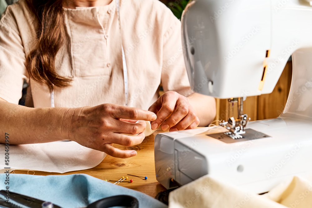 Seamstress basting and sewing in a small studio. Sartorial clothes ...