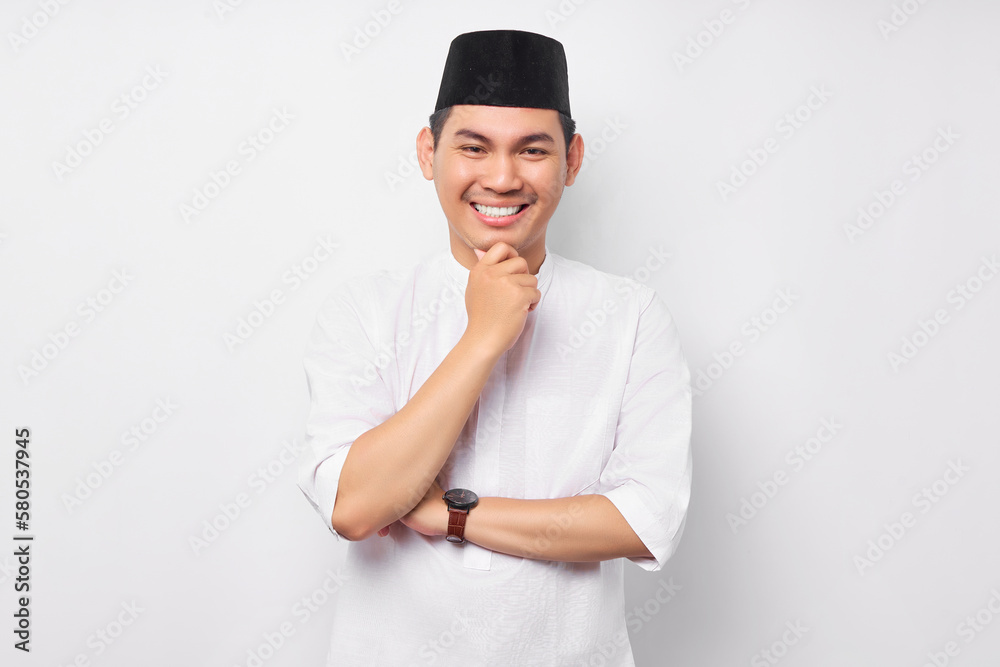 Smiling young Asian Muslim man feeling satisfied and pressing hands ...