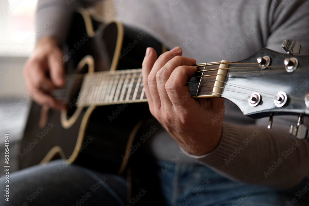 Playing the guitar. Strumming black acoustic guitar. Musician plays ...