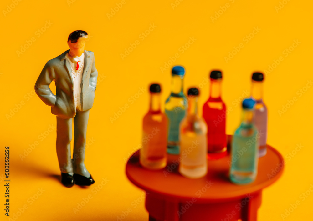 miniature figure of a man with alcohol bottles in front of him Stock ...