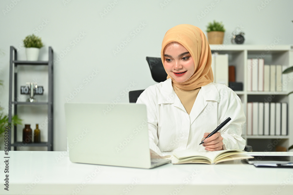 Beautiful muslim woman wearing a hijab using laptop computer and ...