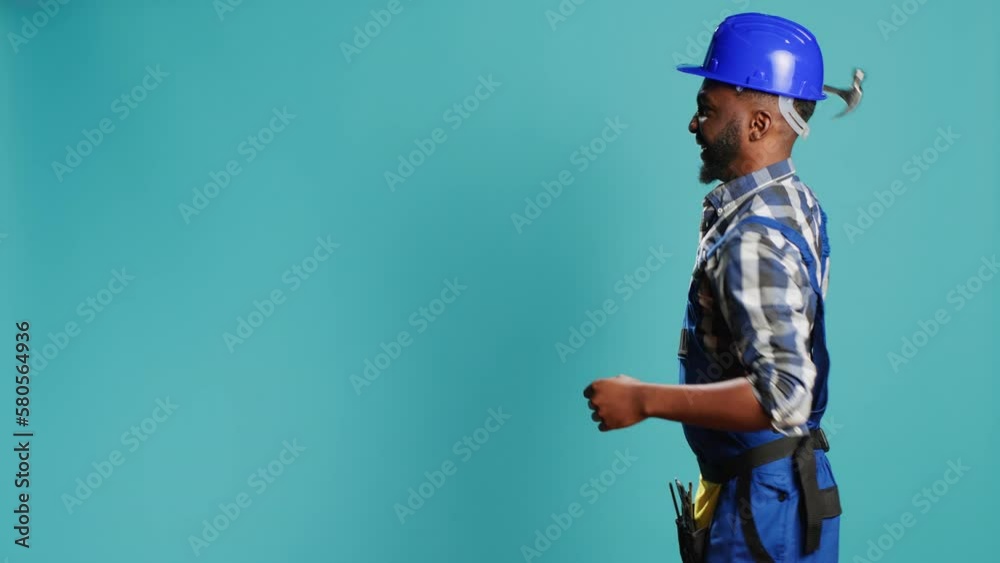 African american carpenter hitting walls with hammer, using manual ...
