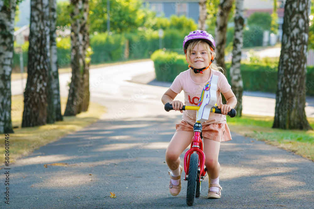 Little preschool girl with helmet running with balance bike on summer ...