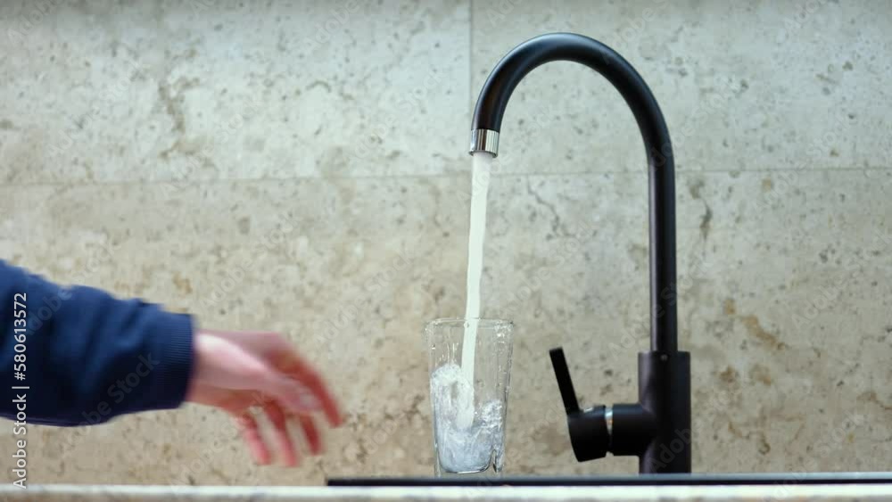 Clean drinking water from the tap. Slow motion. A glass of water, a ...