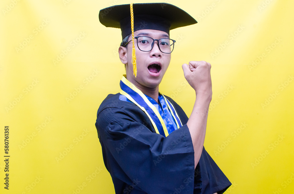 asian young man clenches his fist and shouts happily to celebrate his ...
