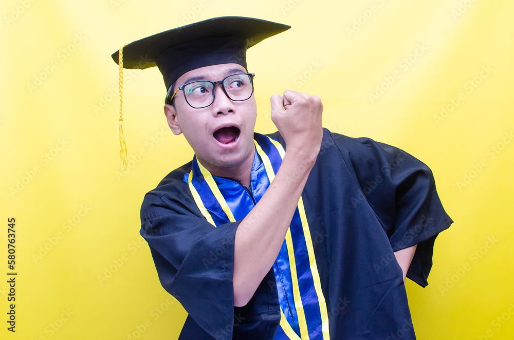 asian young man clenches his fist and shouts happily to celebrate his ...
