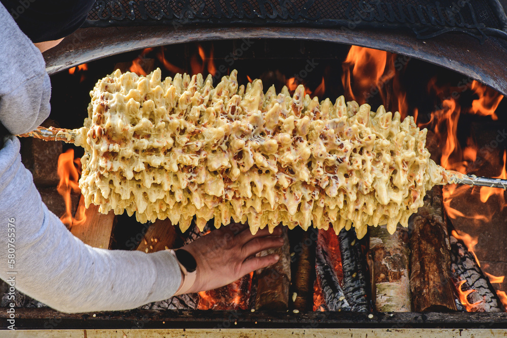 Preparing Lithuanian tree cake, šakotis or baumkuchenas, Polish sękacz ...