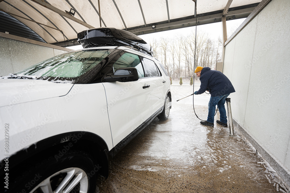 Man washing high pressure water american SUV car with roof rack at self ...