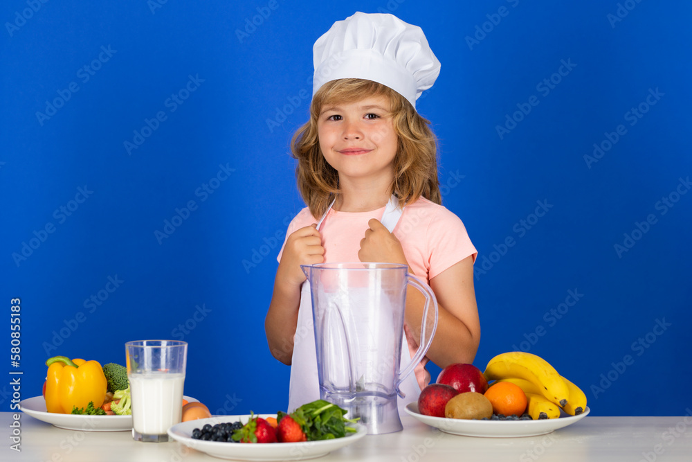 Kid boy in chef hat and apron cooking preparing meal. Little cook with ...