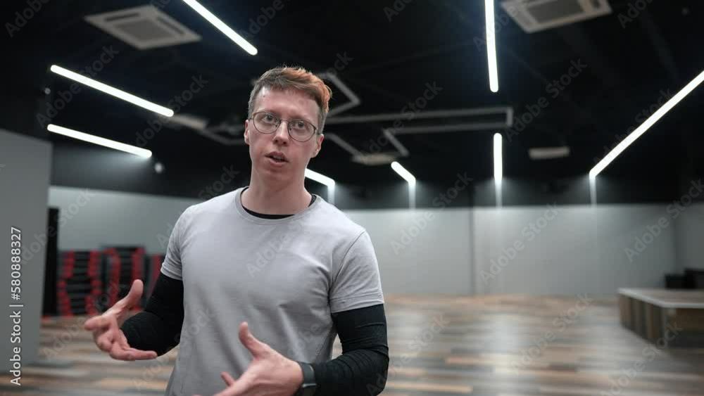 Active goal oriented sportsman instructor in glasses trains in the gym ...
