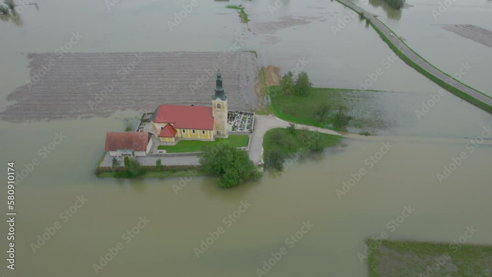 Vidéo Stock AERIAL: Village church and cemetery are surrounded by ...