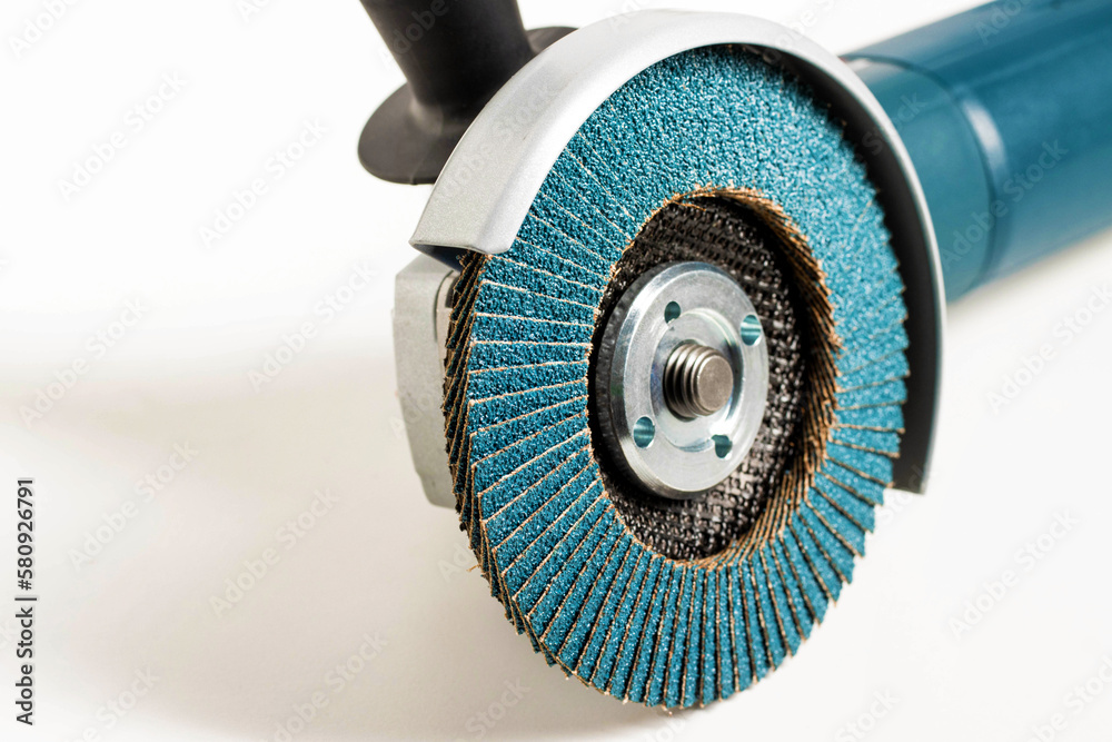 Modern professional angle grinder with a flap wheel on a white ...
