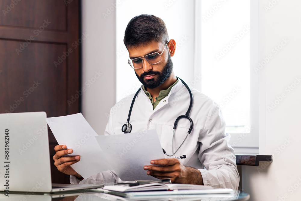 indian doctor wearing uniform taking notes in medical documents Stock ...