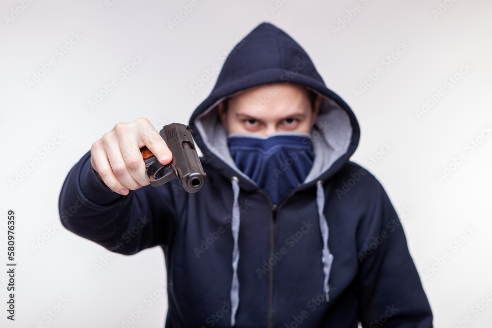 The male criminal in action of attacking with hand gun pointing gun to ...