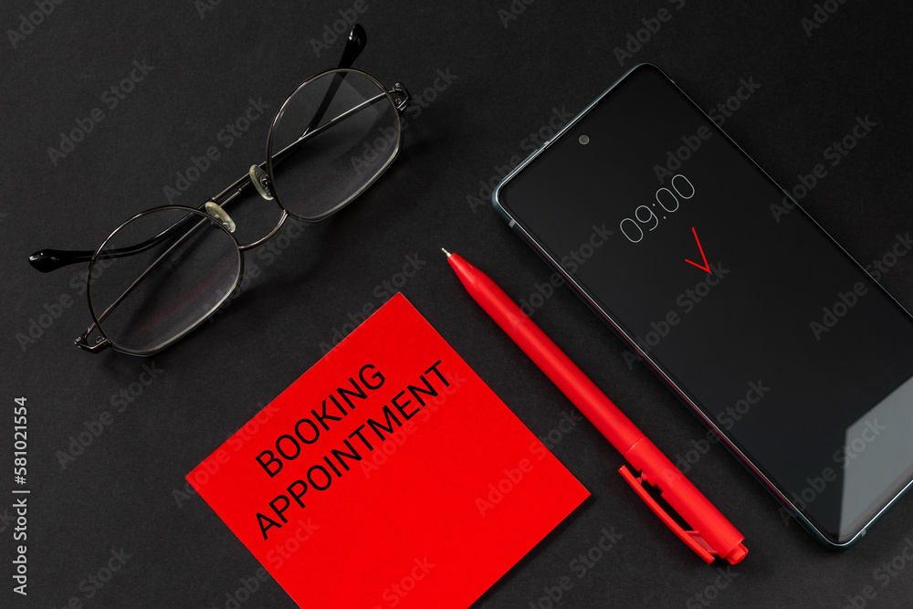 Booking appointment. Text on red tear-off sheet from block, a pen ...