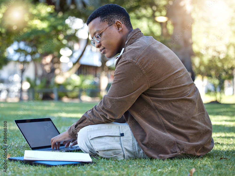 Black man reading, park and student laptop work in a garden with a ...