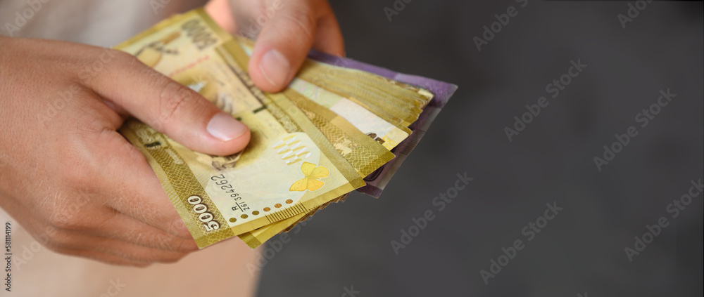Banner. Hands of man counting Sri Lankan rupees of different ...