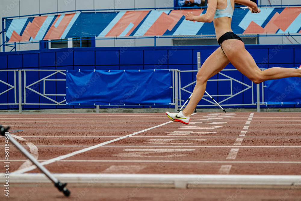 female runner crosses finish line of 100-meter race in athletics ...