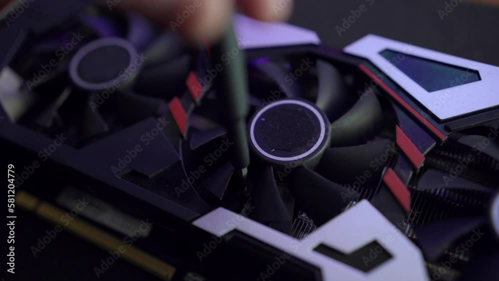A computer technician takes apart a dirty video card to remove dust ...