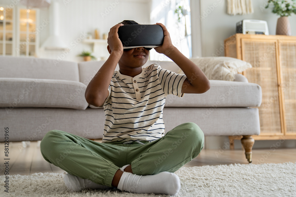 African American boy child sitting on floor in living room wearing ...