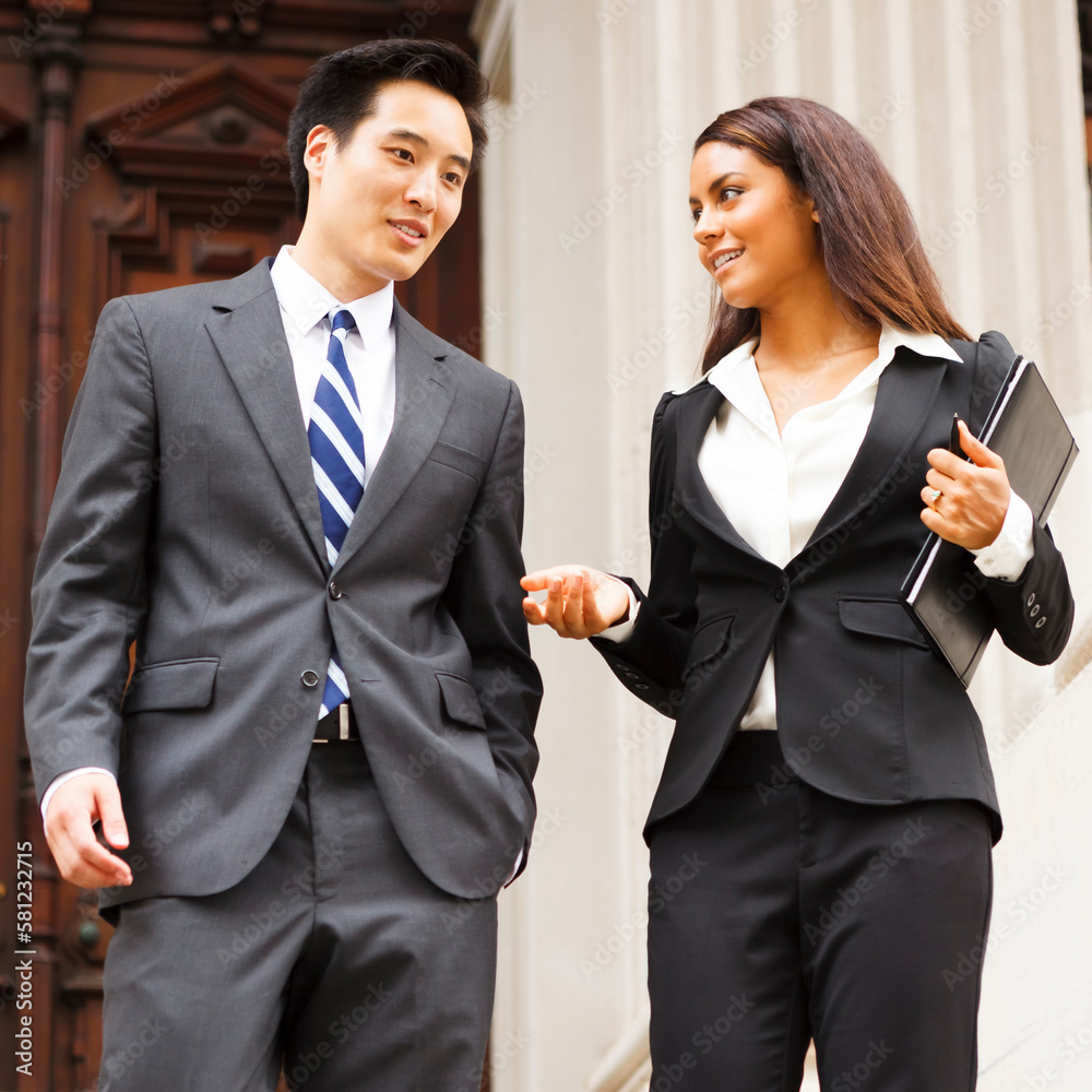 A lawyer and their client walk down the staircase of a courthouse. They ...