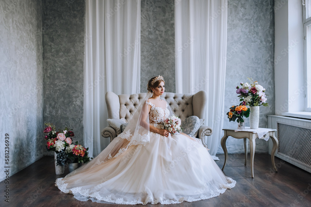 Beautiful bride model in a white lace dress with a crown, diadem sits ...