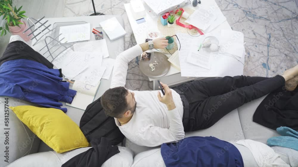 Tired lazy man lying on sofa in his untidy room. Messy and lazy man ...